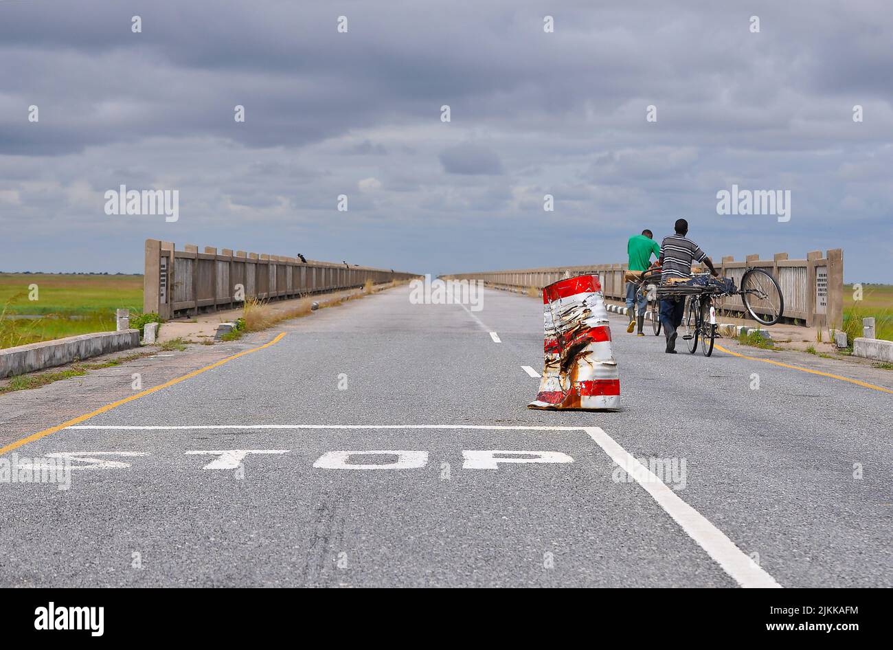 A group of people pushing their bicycles over the Luapula bridge over ...