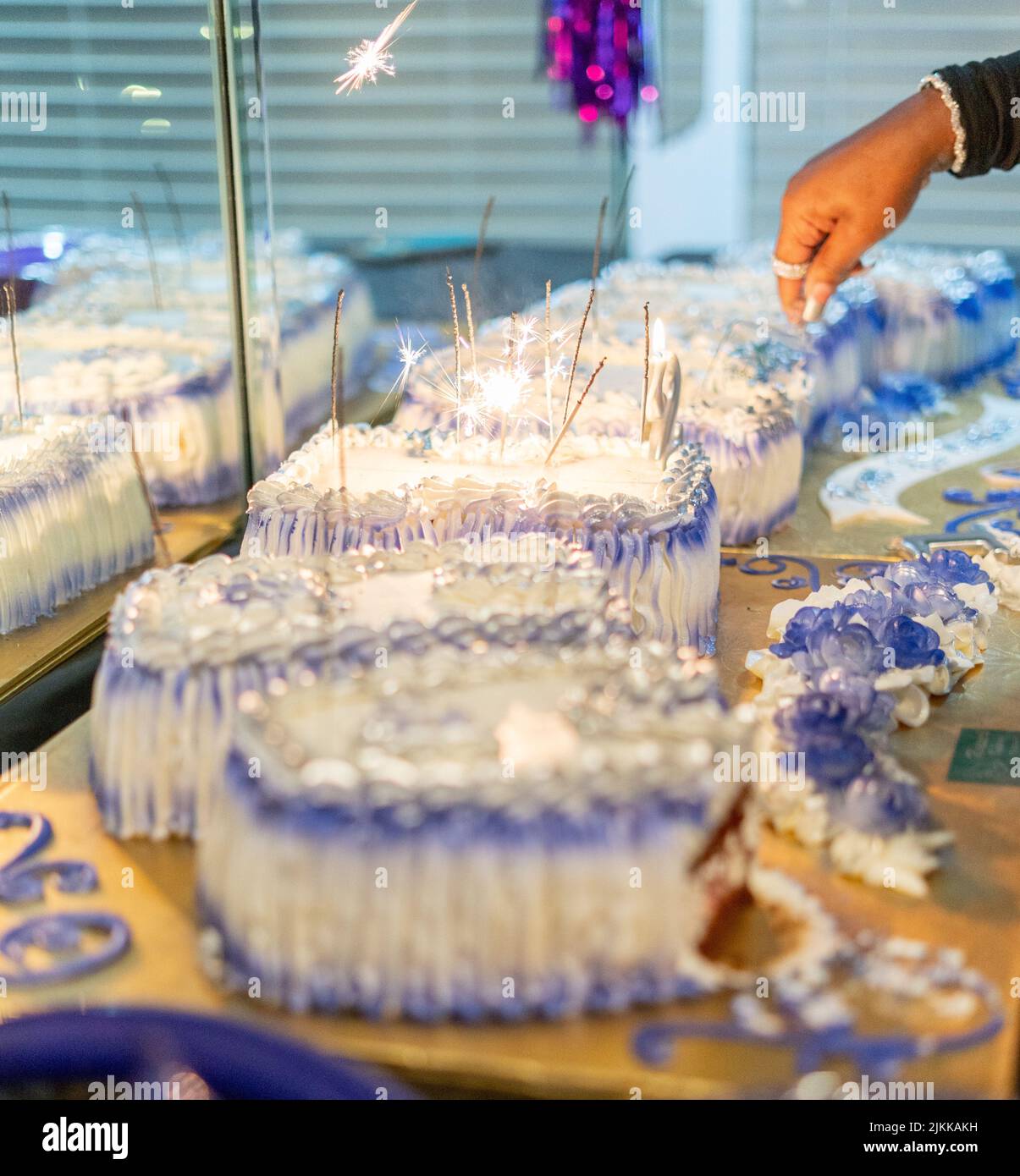 A vertical shot of birthday cakes decorated with white and purple cream ...
