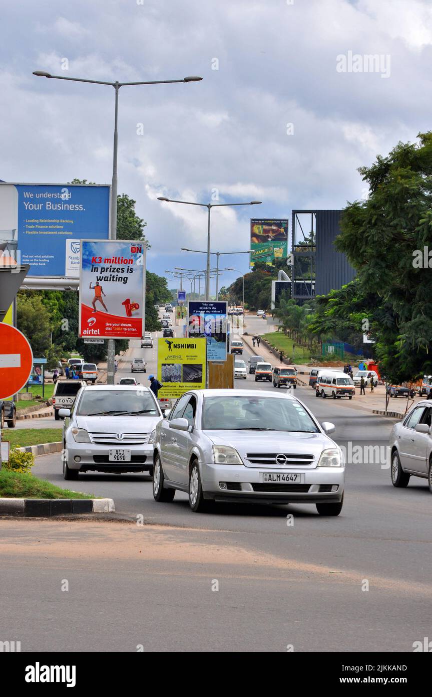 A vertical shot of a street with heavy road traffic and advertisement ...