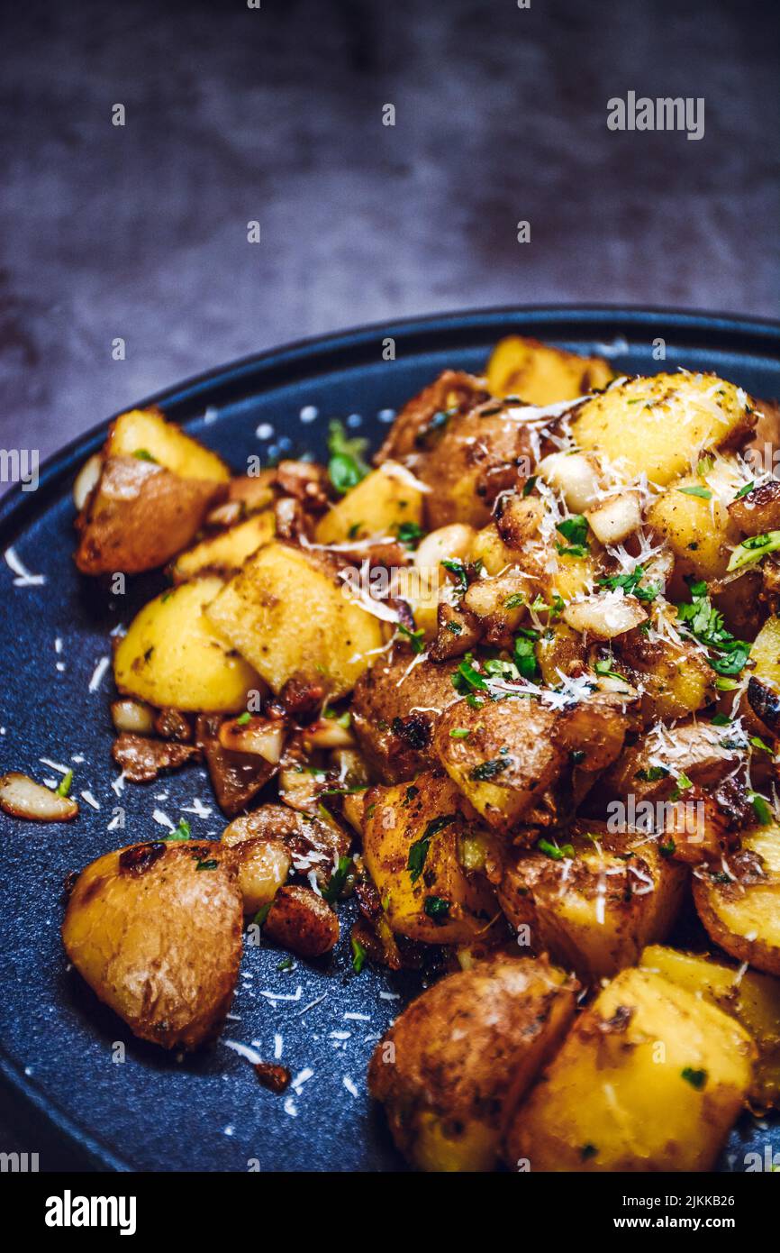 A vertical closeup shot of a homemade meal with grilled potatoes with ...