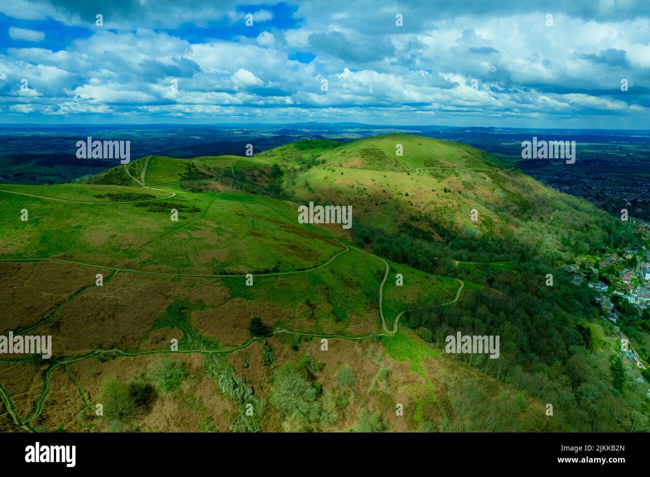 A scenic view of a hill with green forests and vegetation on cloudy sky ...