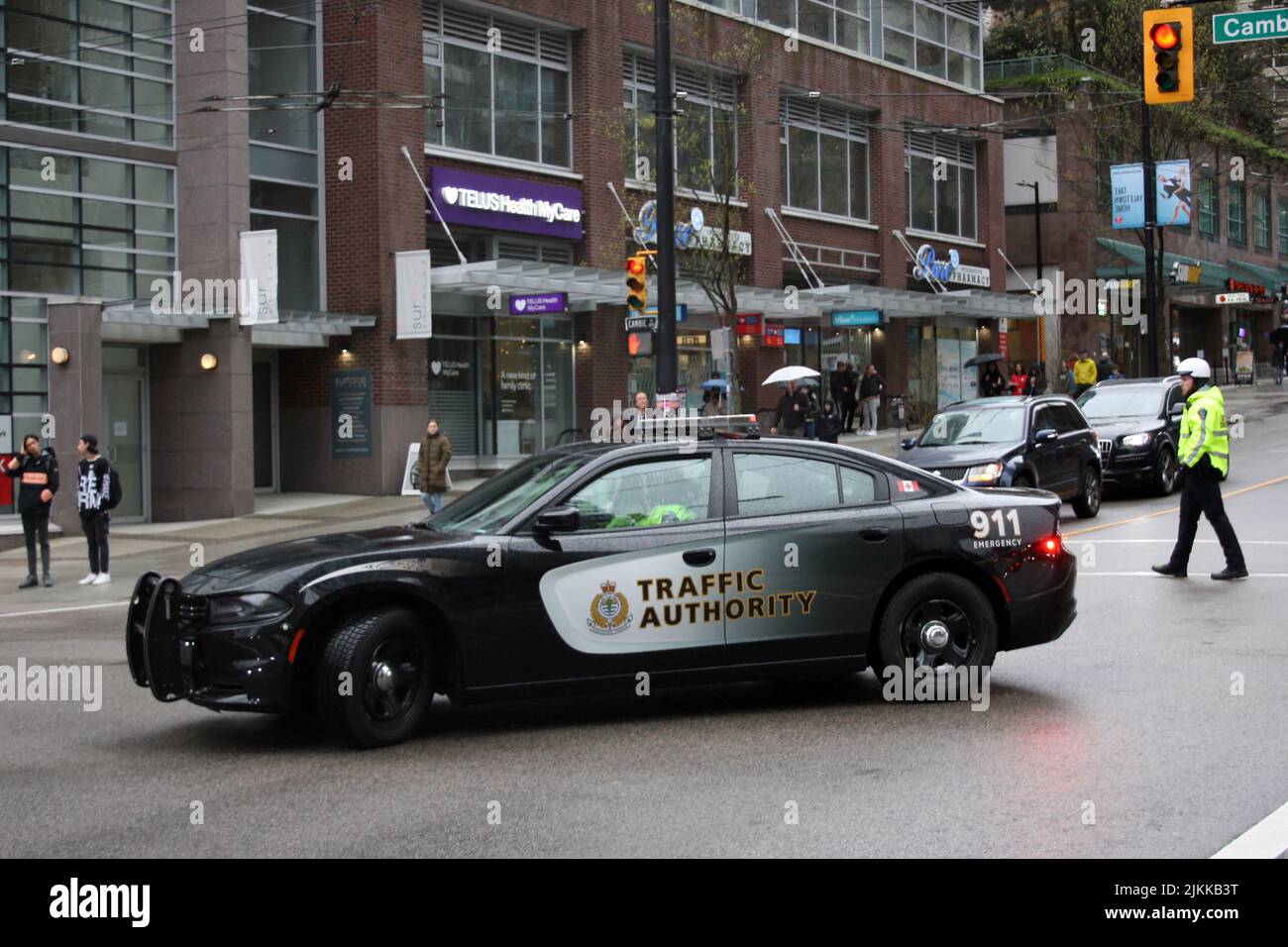 A black Traffic Authority car in the middle of a downtown street next ...