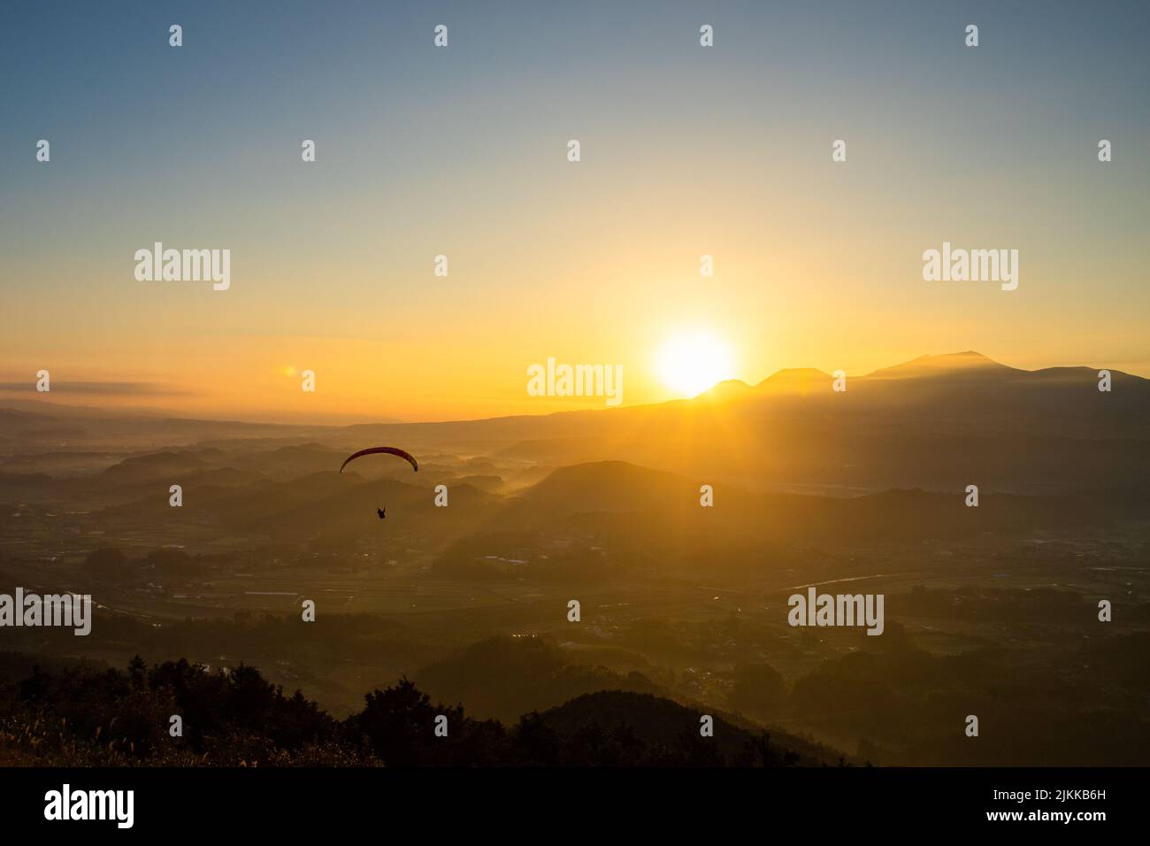 A view of human flying with Paraglider over the mountains during ...