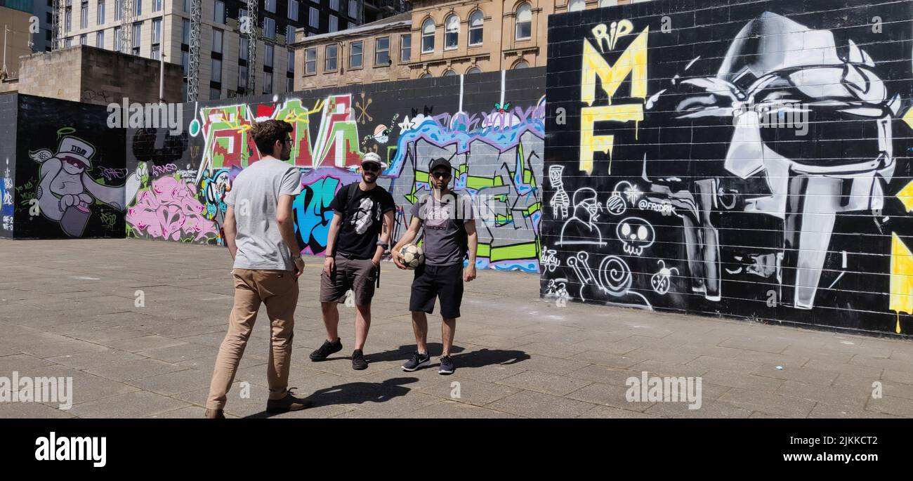 The three young males against the colorful and artistic graffiti wall ...