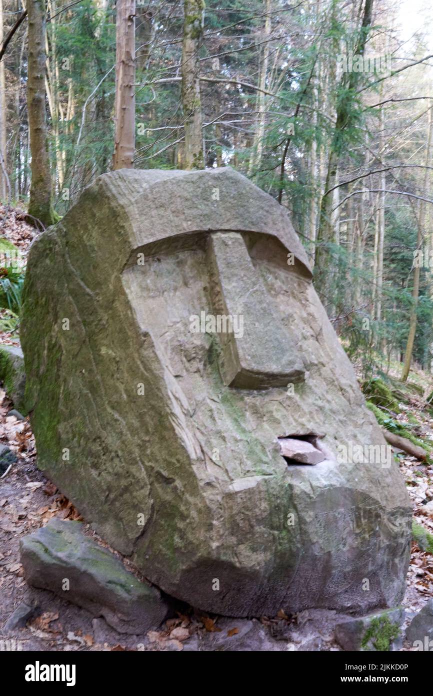 A huge rock carved with a face shape in the forest in autumn Stock ...