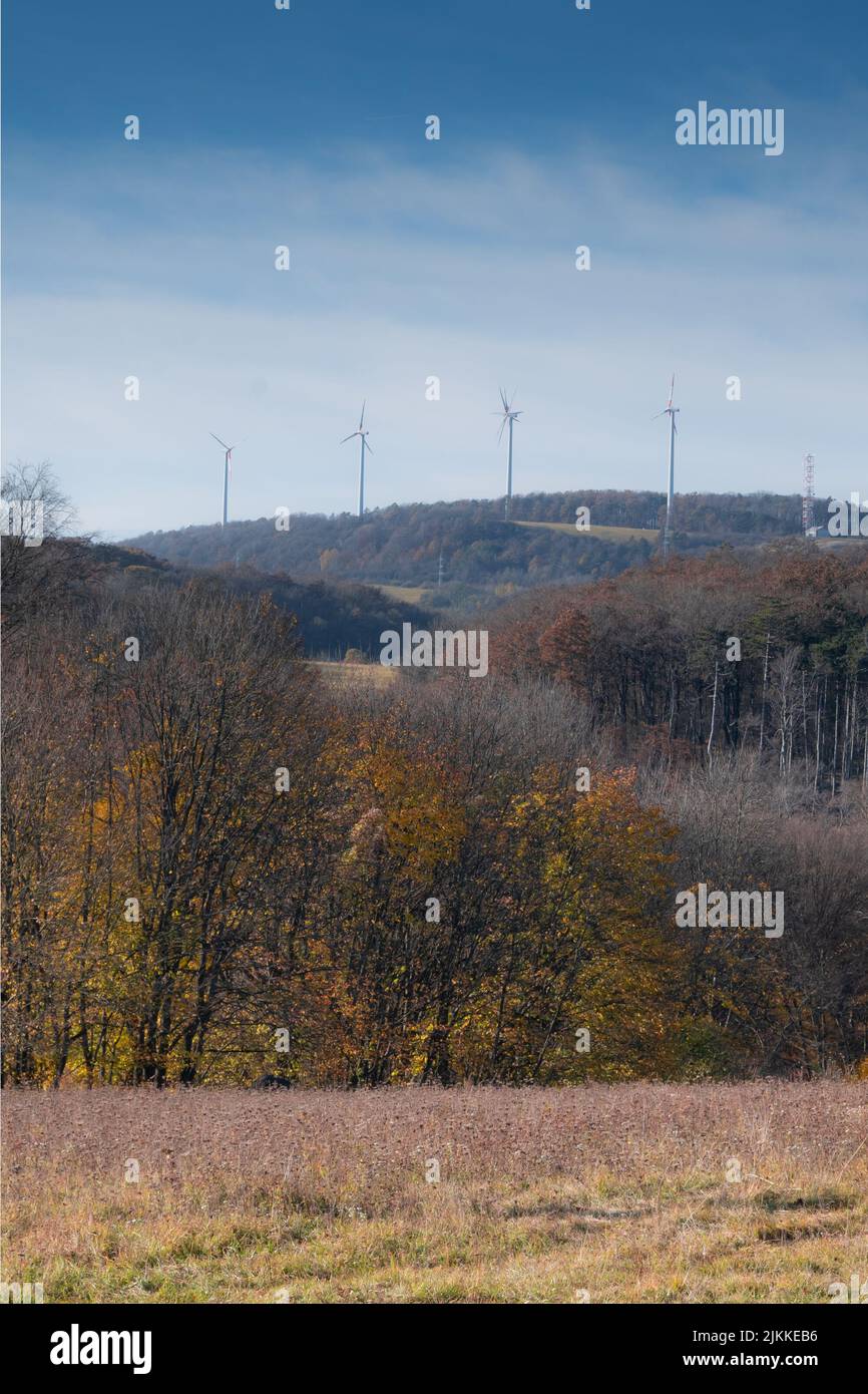 A group of trees on a hill and electrical fans in the background Stock ...