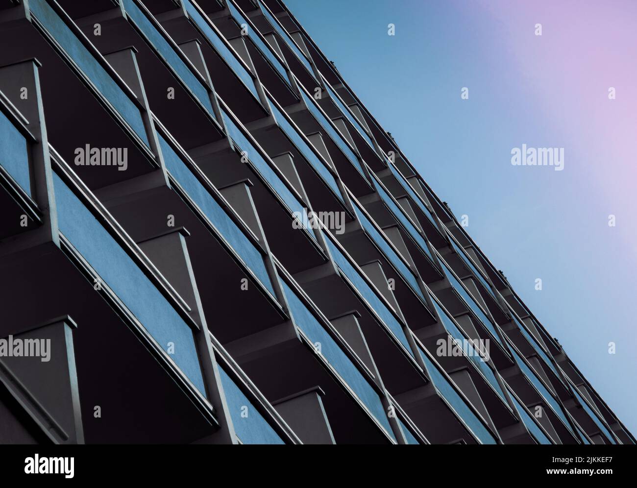 A low angle shot of a reflective glass building under a purple blue sky ...