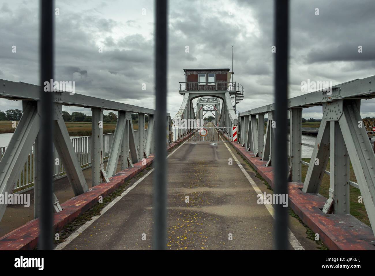 A closed bridge through a grid with the dramatic sky behind Stock Photo ...