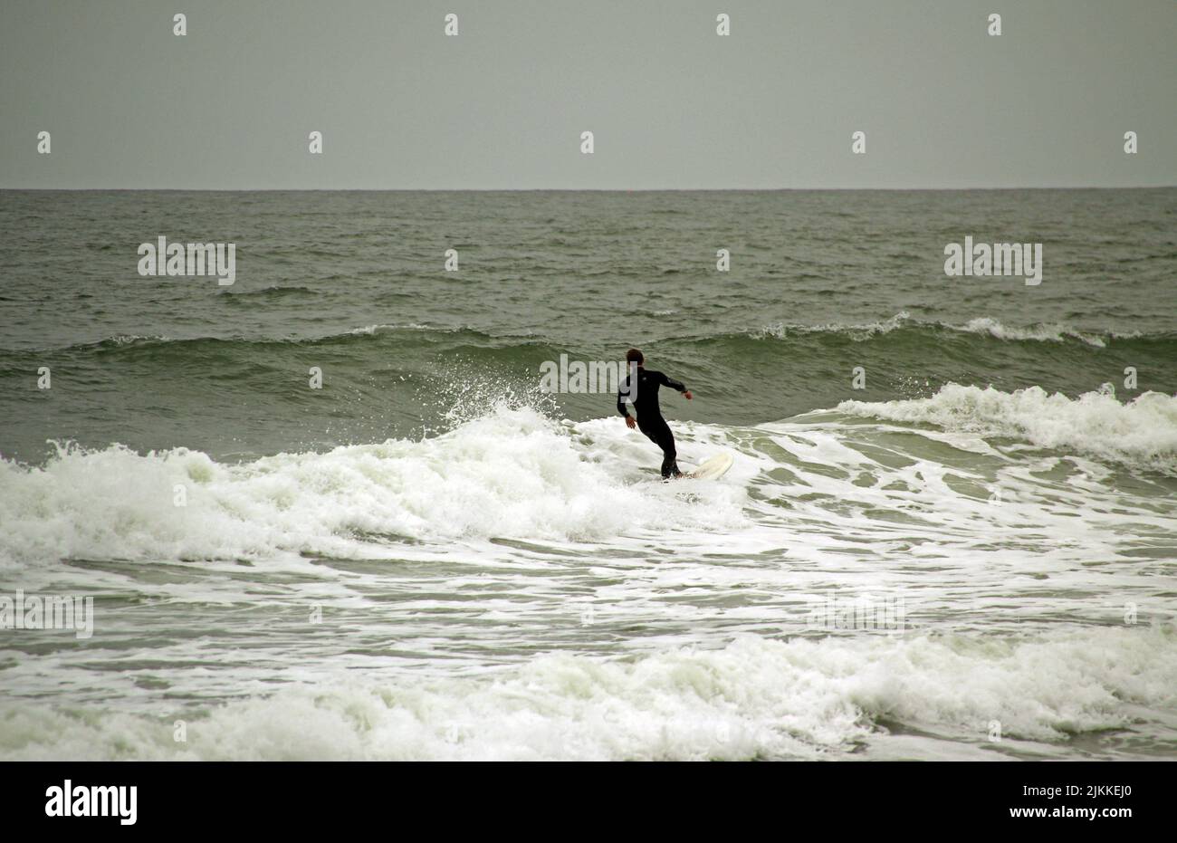 A surfer catching the waves in the ocean Stock Photo - Alamy