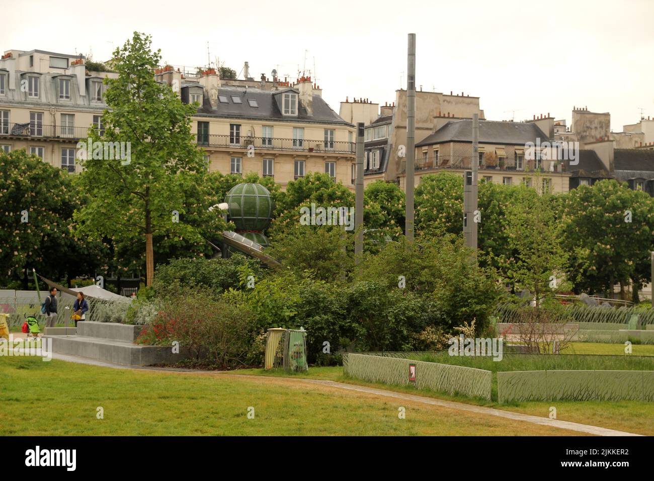 A beautiful park with trees and plants surrounded by old buildings in ...