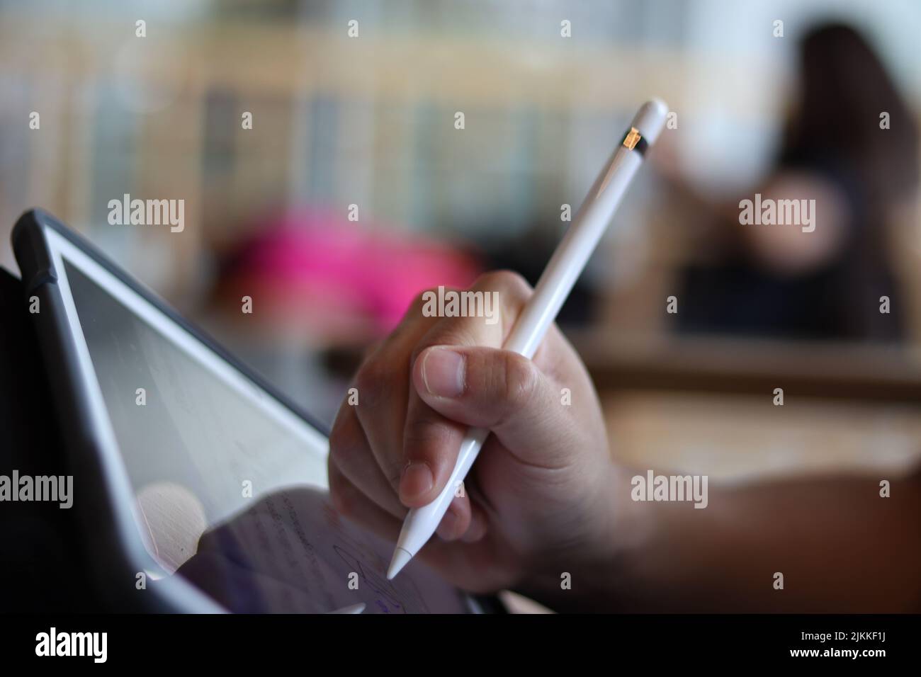 A closeup of the hand working on the tablet with a wireless stylus pen ...