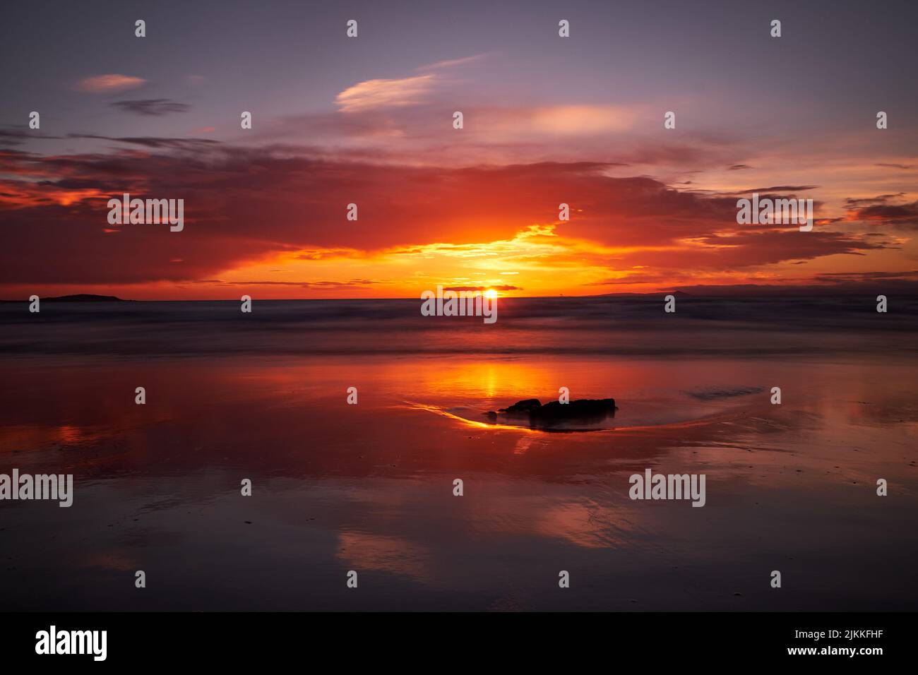 A scenic view of sunset over a body of water with the colorful sky ...