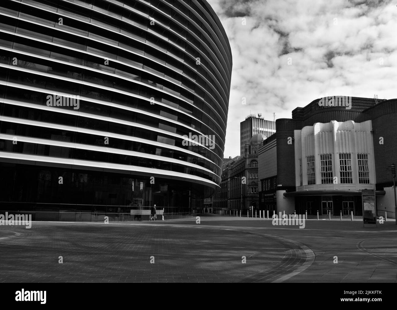 A grayscale shot of a part of a circular modern building, an open space ...
