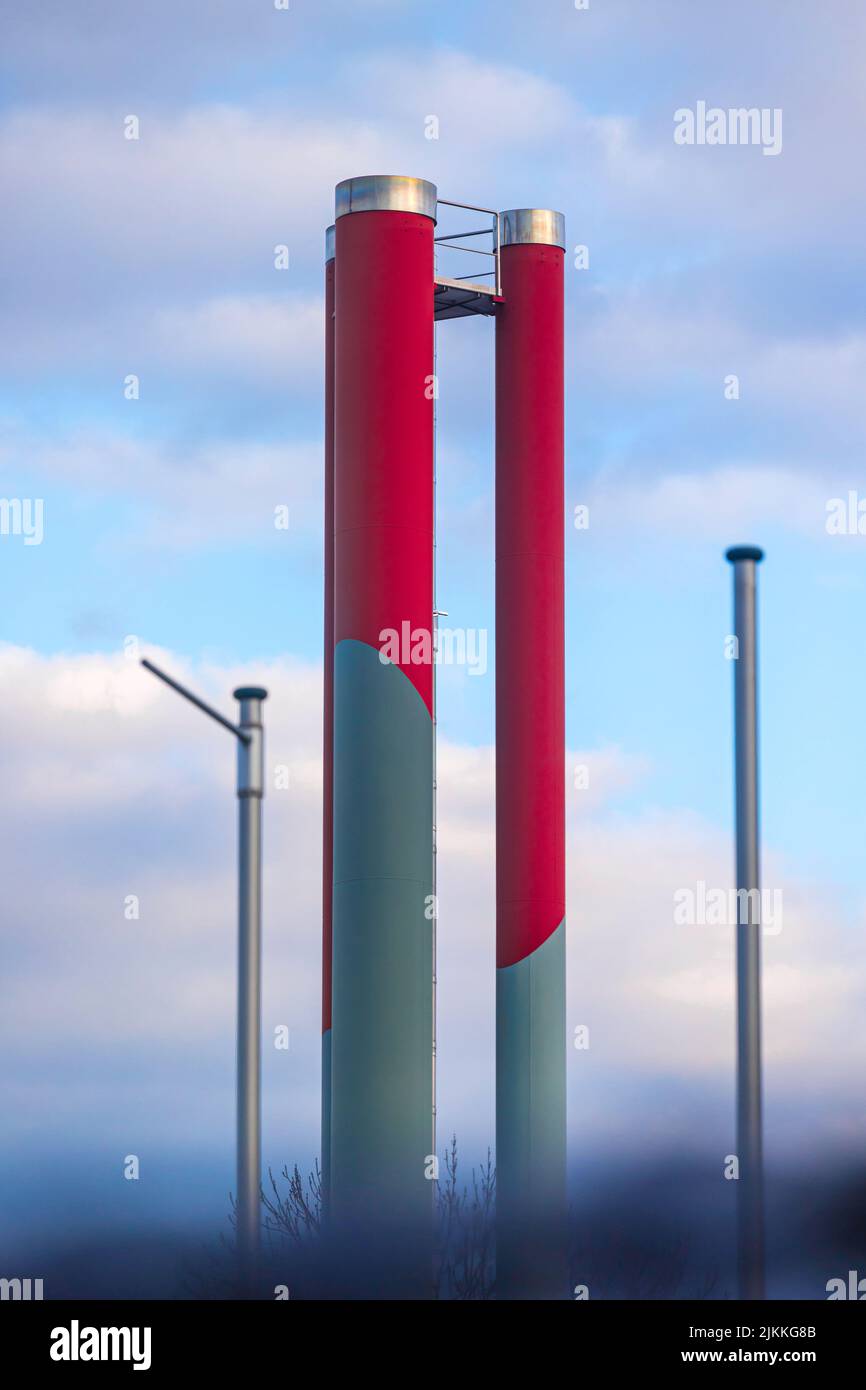 A selective focus shot of red and grey high chimneys with a purple sky ...