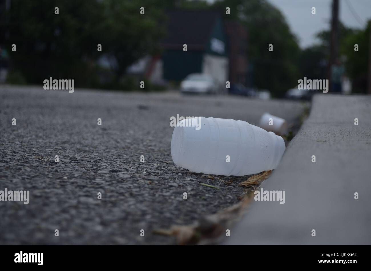 A shallow focus shot of a white plastic bottle on the floor in the ...
