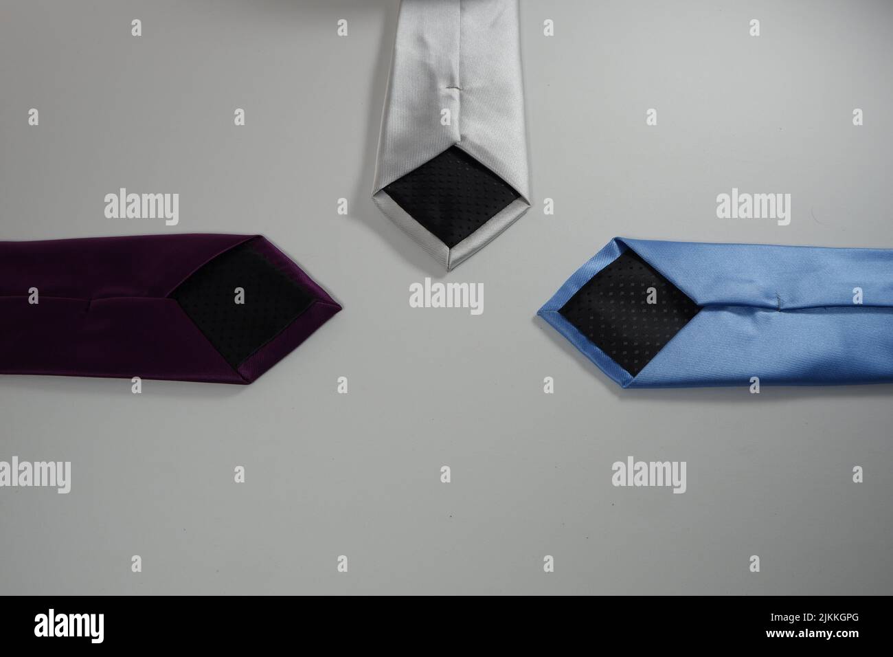 A three multi colored ties on a white background Stock Photo - Alamy