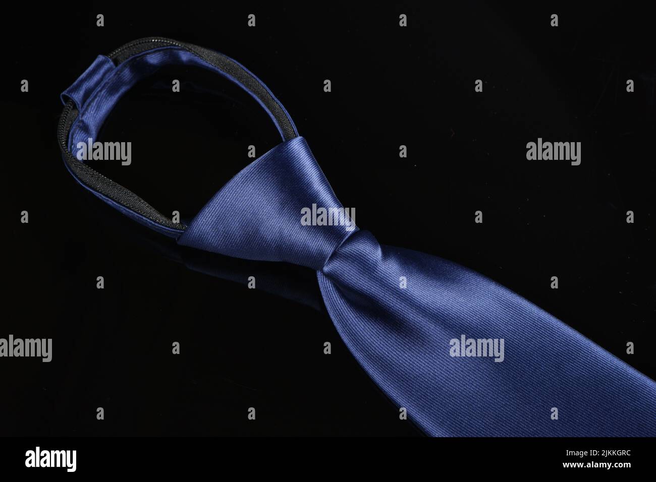 A blue zipper necktie with a tie knot on a black background Stock Photo ...