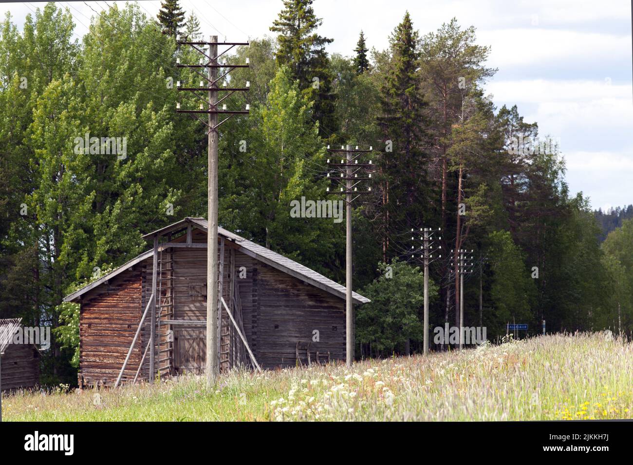 Old wooden timber barns. Wildflower, meadows, and telephone lines ...