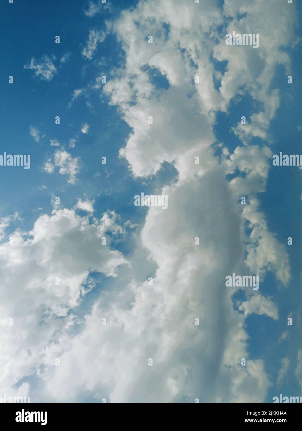 A vertical low angle shot of the blue sky with cumulus clouds Stock ...