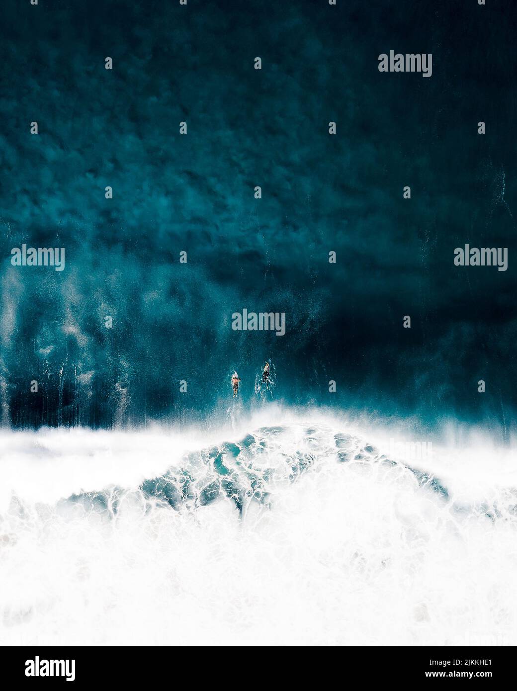 A bird's eye view of surfers on a wavy body of water. Great for ...
