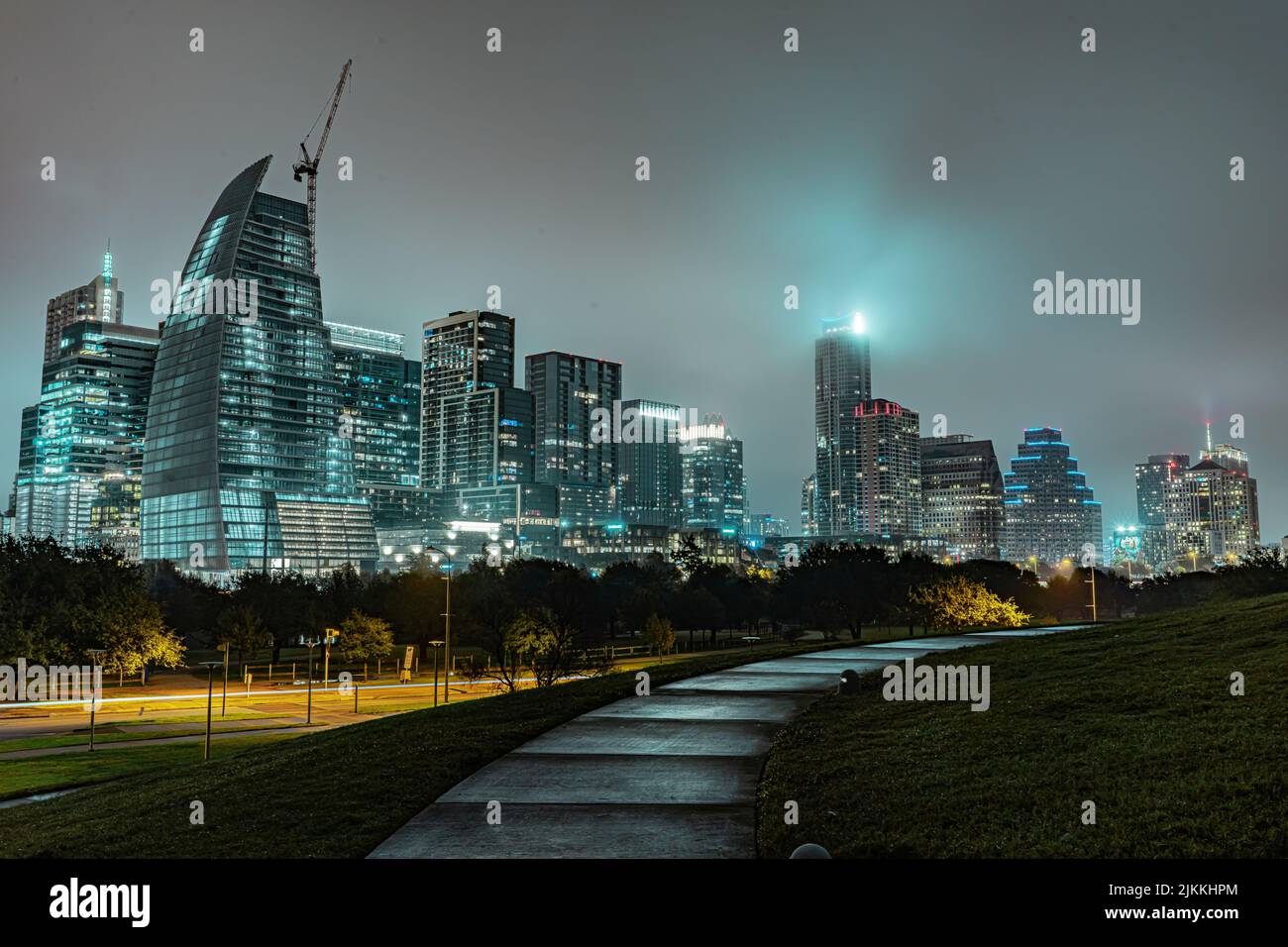 A horizontal shot of a skyscrapers at night on a foggy sky background ...