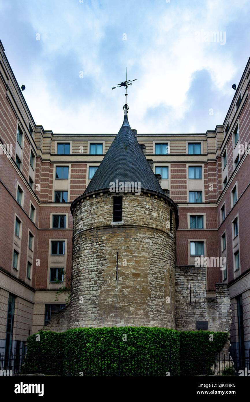 A medieval tower surrounded by a building in downtown Brussels, Belgium ...