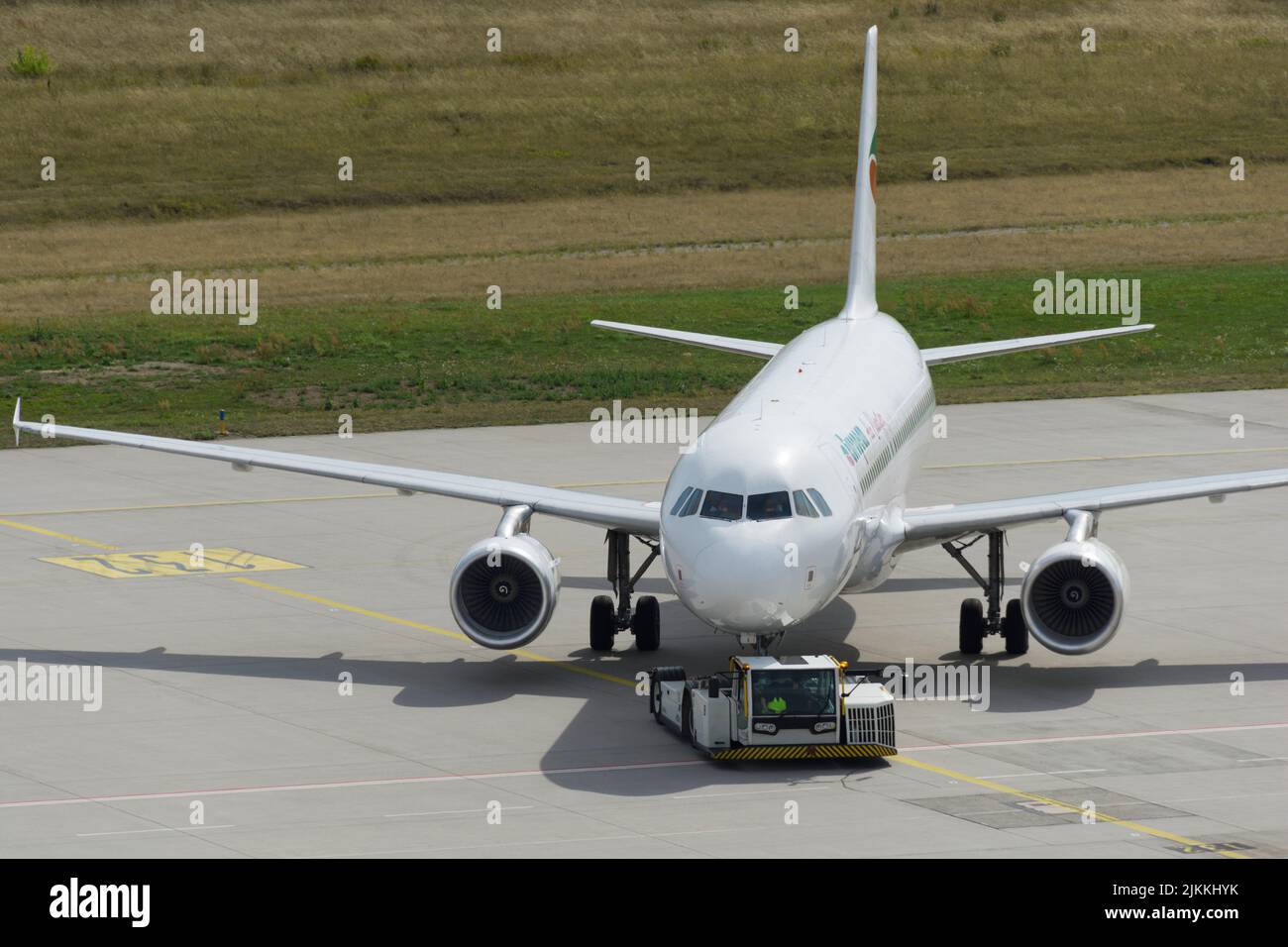 Aircraft tug pushes jet backwards from parking position Stock Photo - Alamy