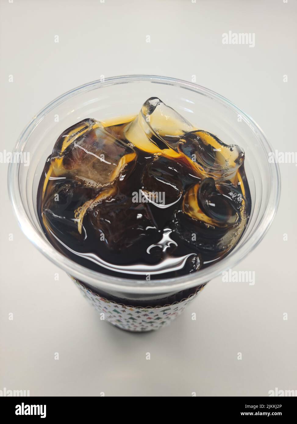 A vertical top view of a refreshing drink in a cup with big ice cubes ...