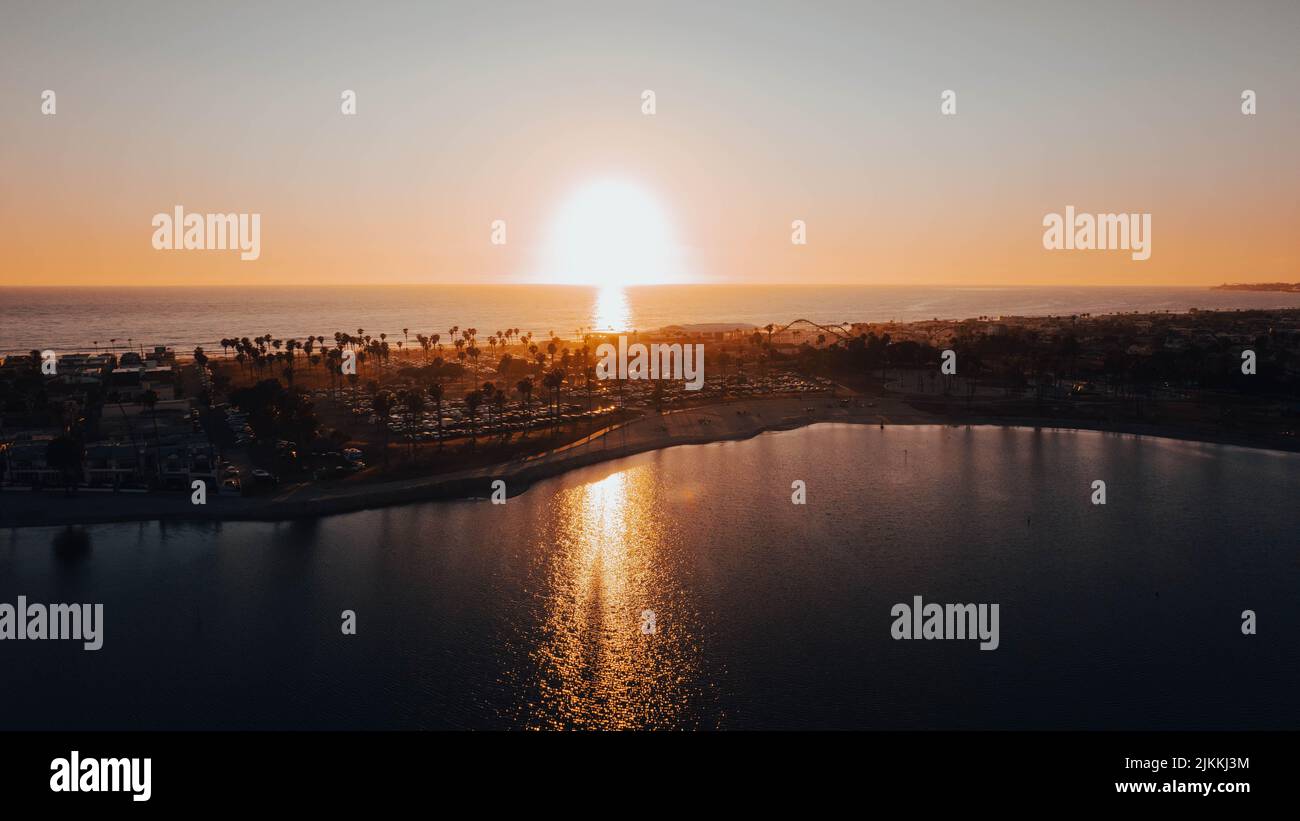 A beautiful golden sunset glistening over the horizon at a small island ...