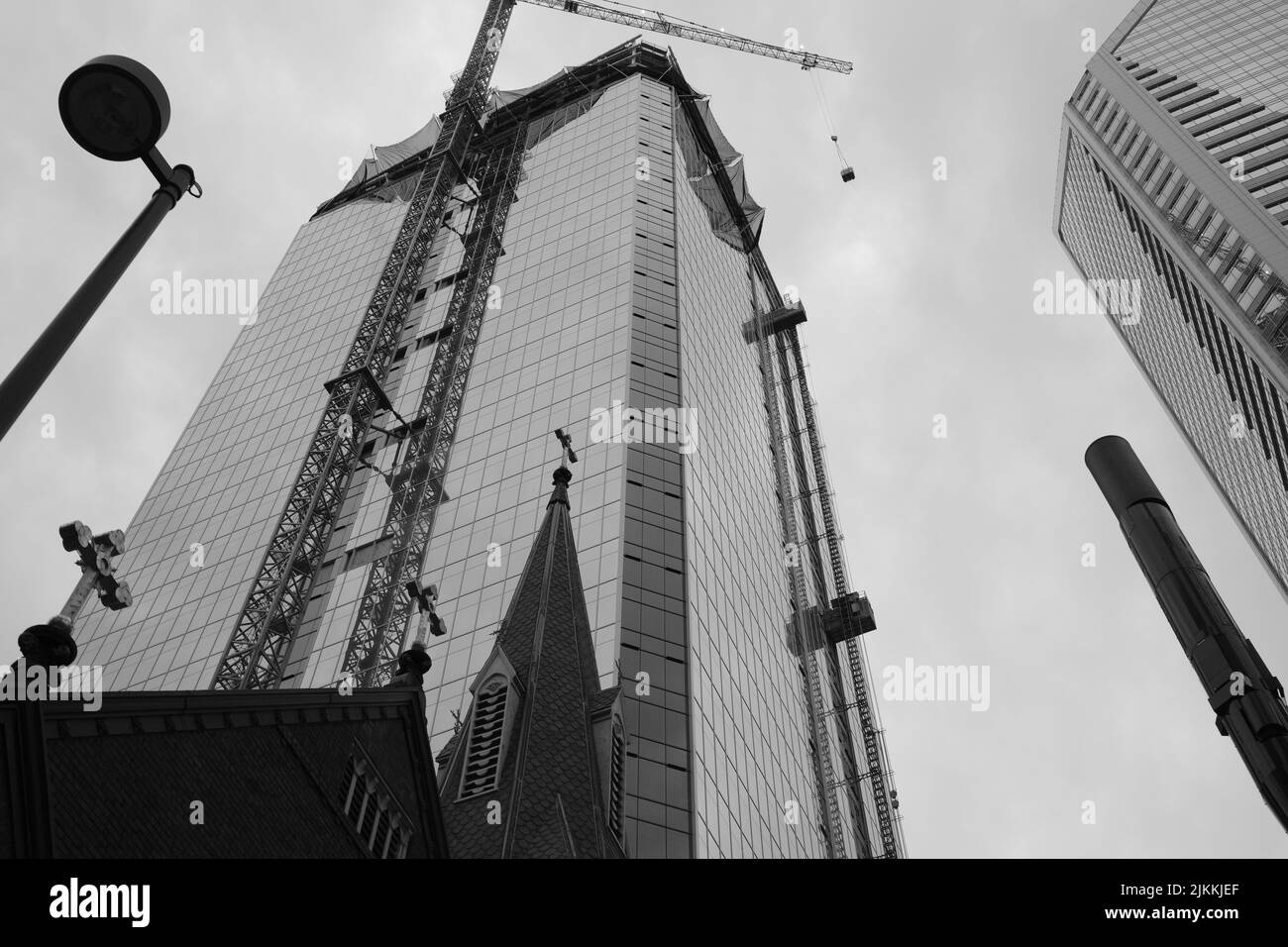 A vertical low angle grayscale view of a skyscraper being built in ...