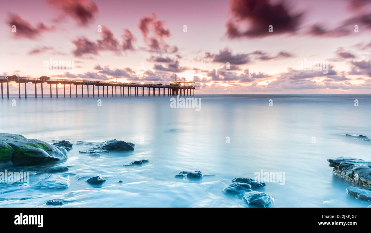 A beautiful bright pink sunset sky over a port in blue water Stock ...