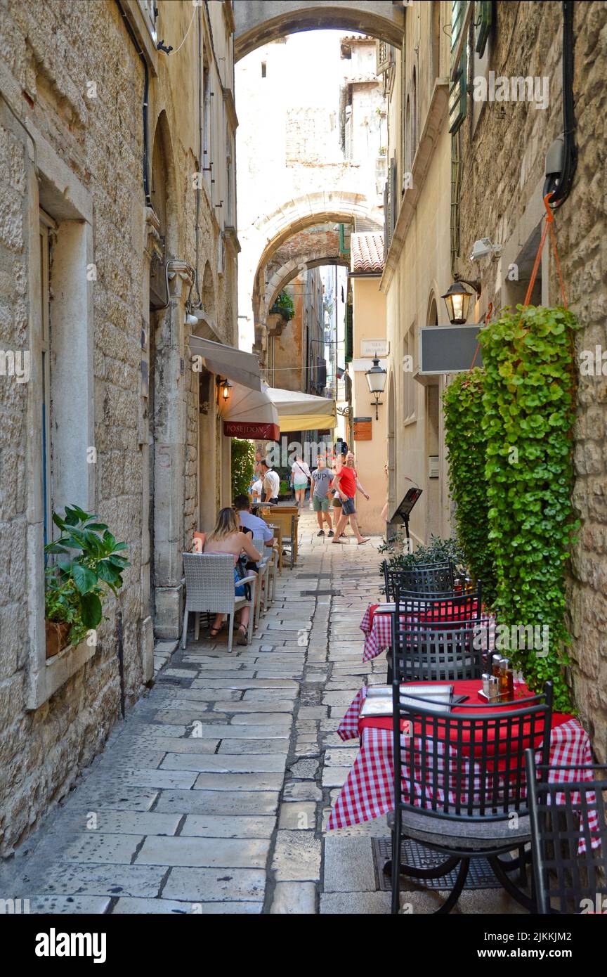 A vertical view of a outdoor cafe in a narrow street in Split, Croatia ...