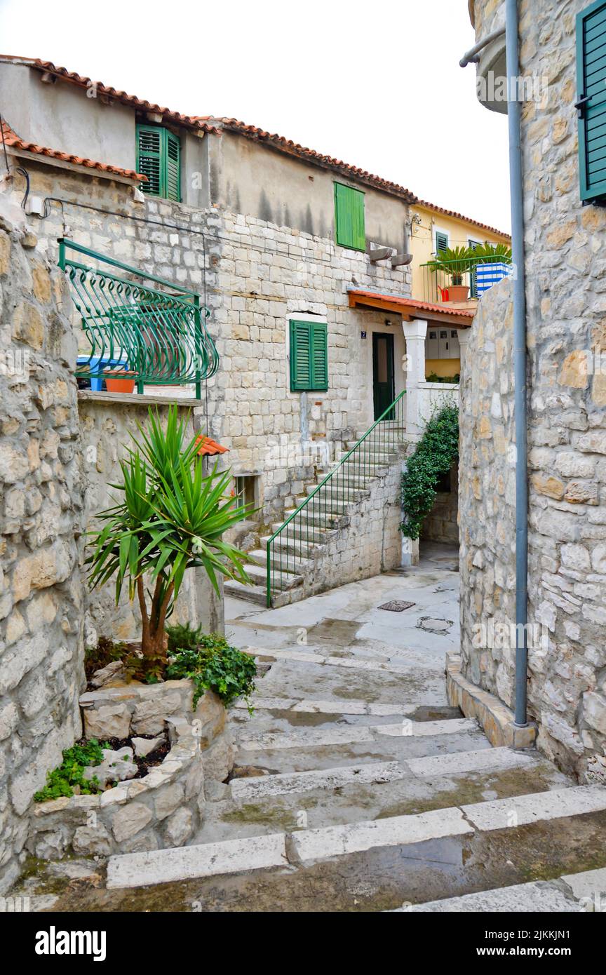 A vertical shot of stone houses with cute exterior in a narrow alley in ...