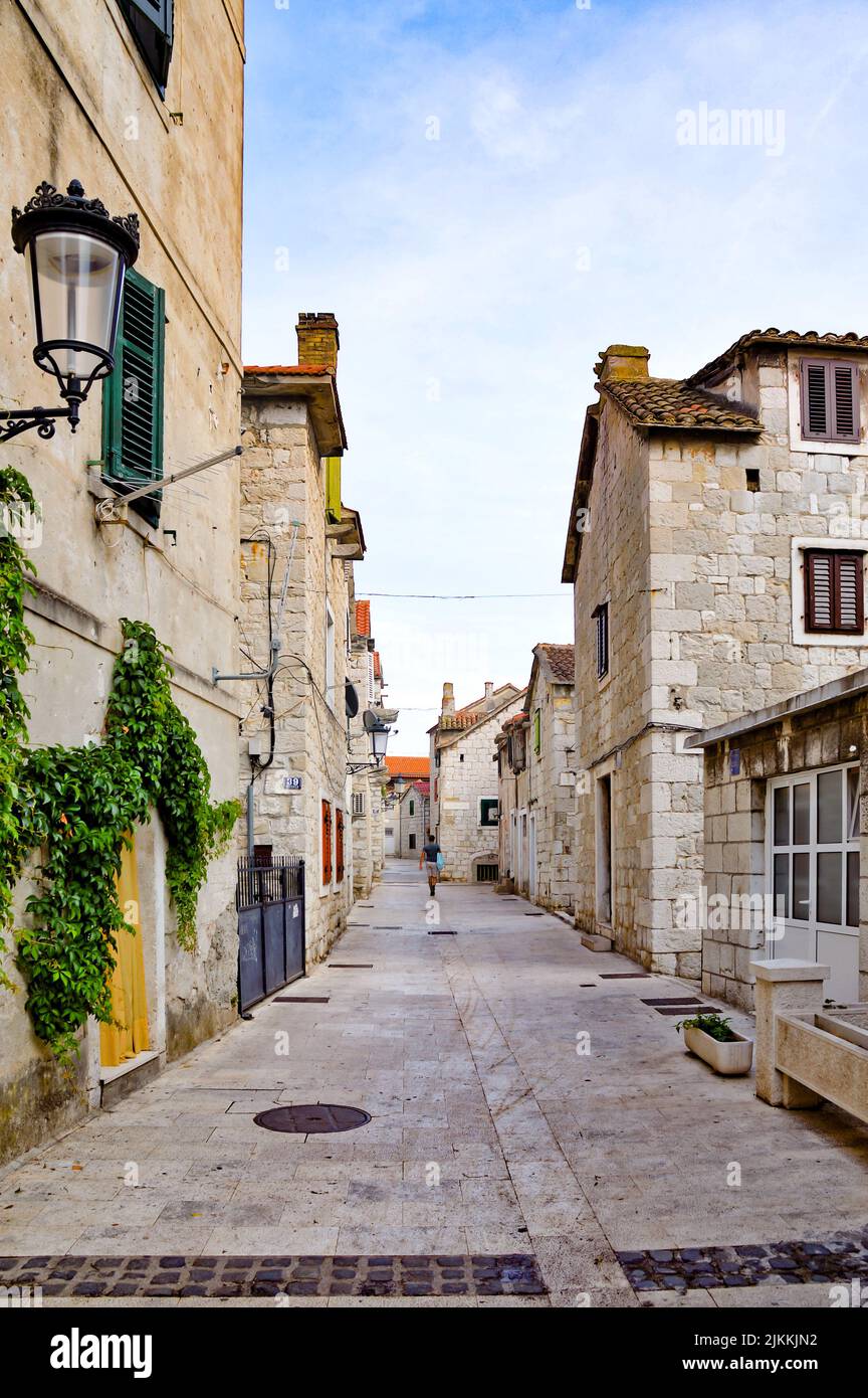 A vertical shot of old beautiful buildings in a narrow alley in Split ...