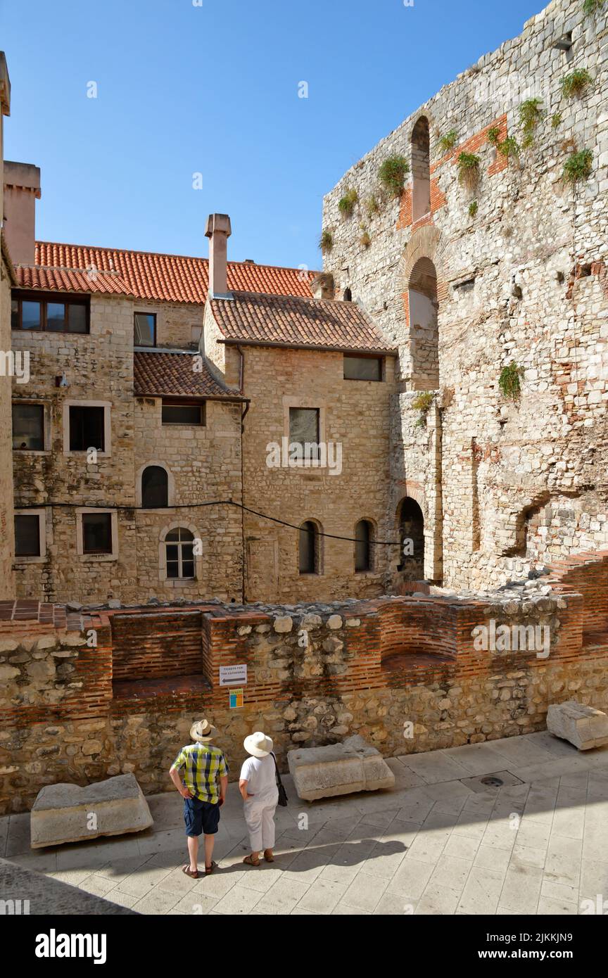 A vertical shot of tourists standing in front of beautiful medieval ...