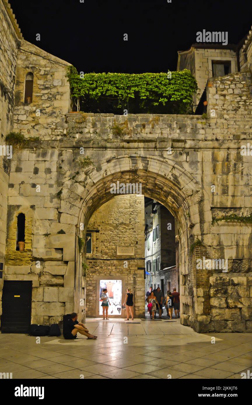 A vertical shot of people walking on a narrow street in the medieval ...