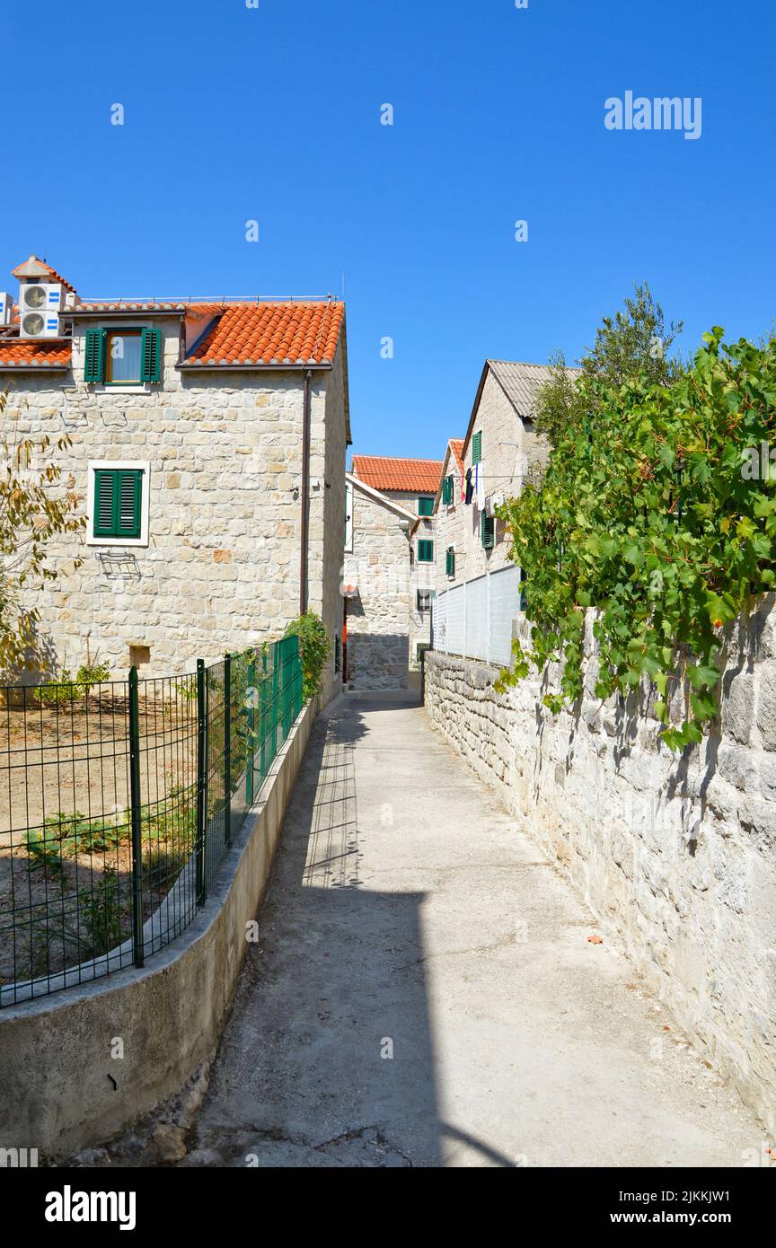 A vertical shot of a narrow alley with beautiful stone buildings in ...