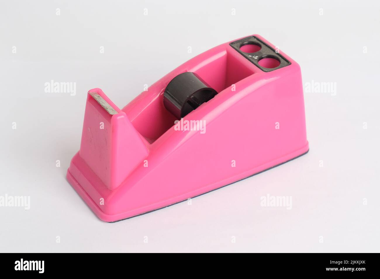 A close-up shot of an empty pink tape dispenser isolated on a white ...