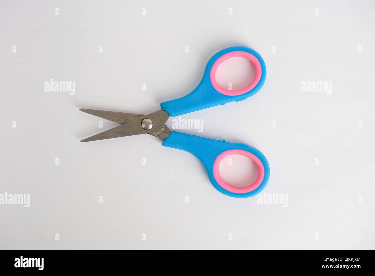 A top view of a scissor with blue and pink handle isolated on a white ...