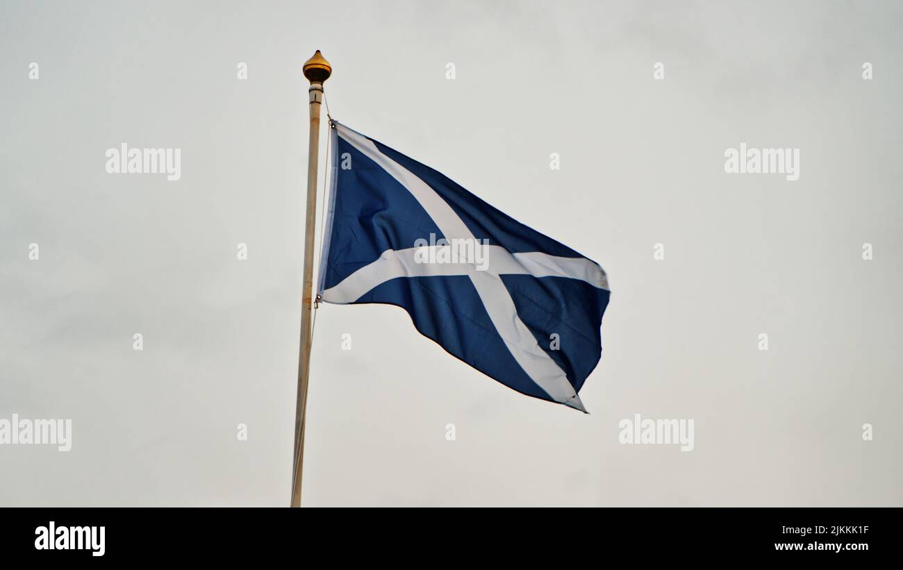 The flag of Scotland waving on a pole against a gray cloudy sky Stock ...