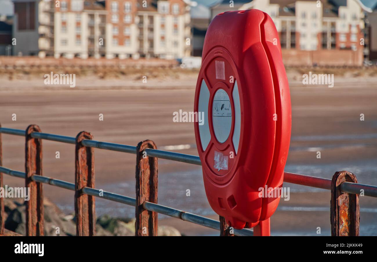 A closeup of a red lifebuoy in front of a metal railing in Ayr ...