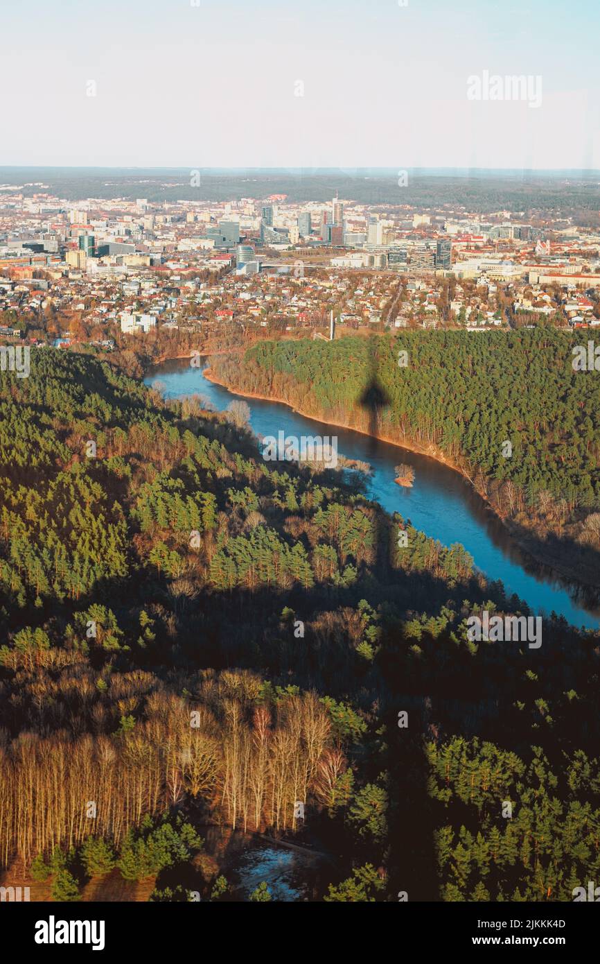 A scenic view of the Vilnius city and a river surrounded by forest ...