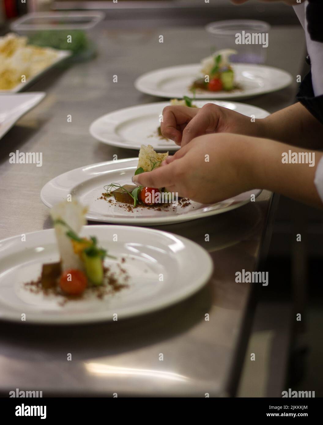 A vertical closeup shot of a professional chef adding the last designs ...