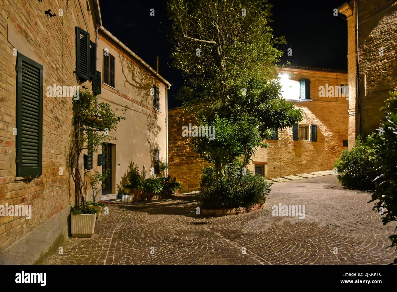 A narrow street between the old houses of Montecosaro, a medieval town ...