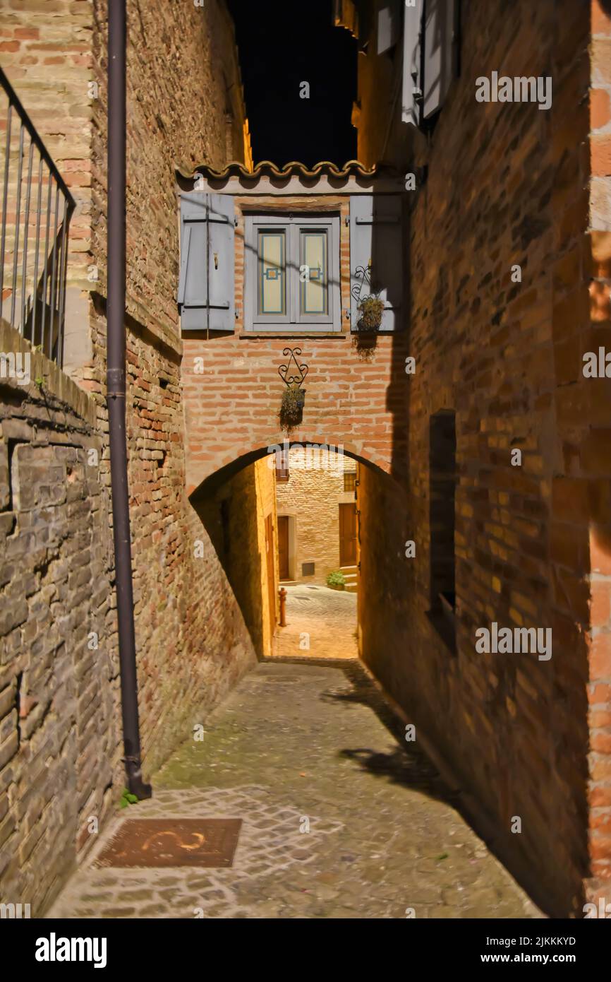A vertical shot of a narrow street between the old houses of ...