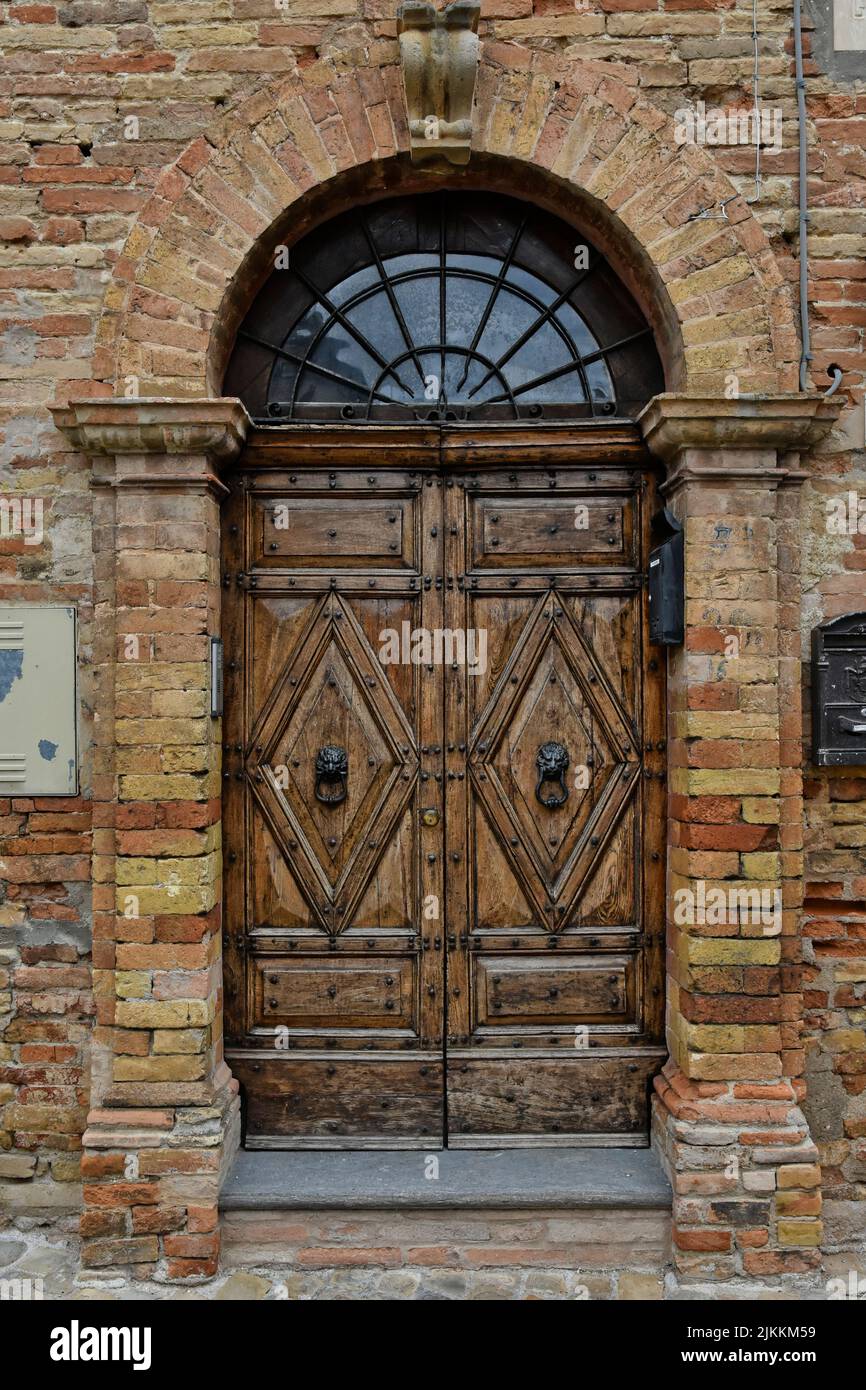 A vertical shot of the front door of a medieval house in Montecosaro ...