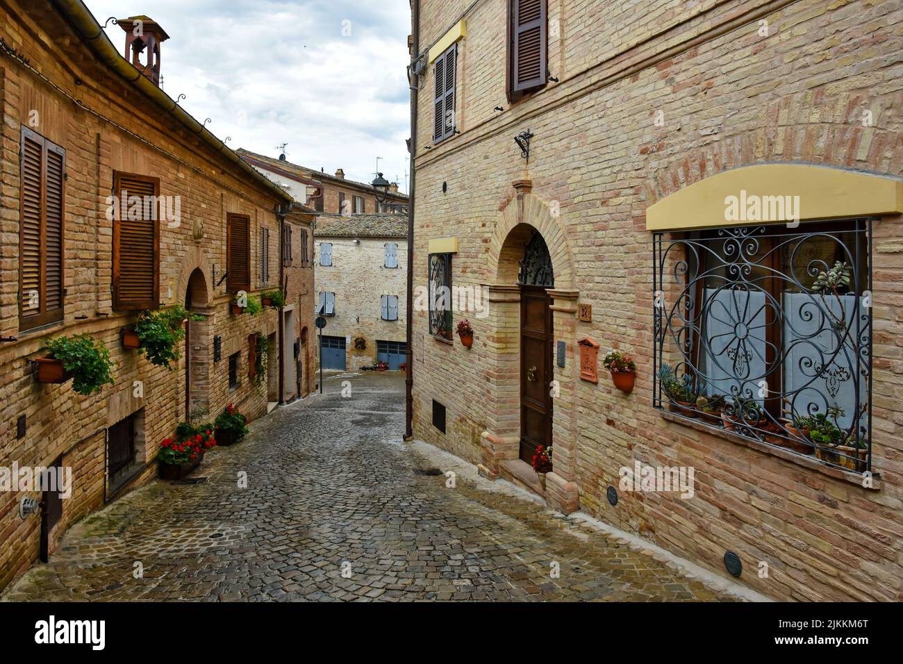 A narrow street between the old houses of Montecosaro, a medieval town ...