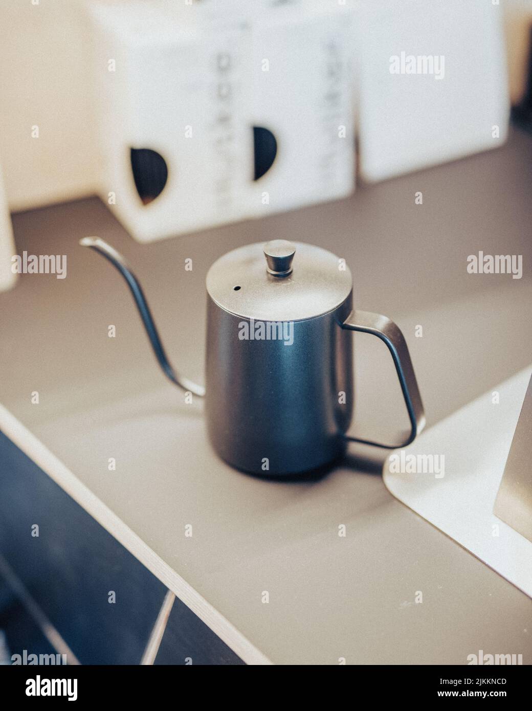 A vertical closeup shot of a contemporary coffee tea pot on a table in ...