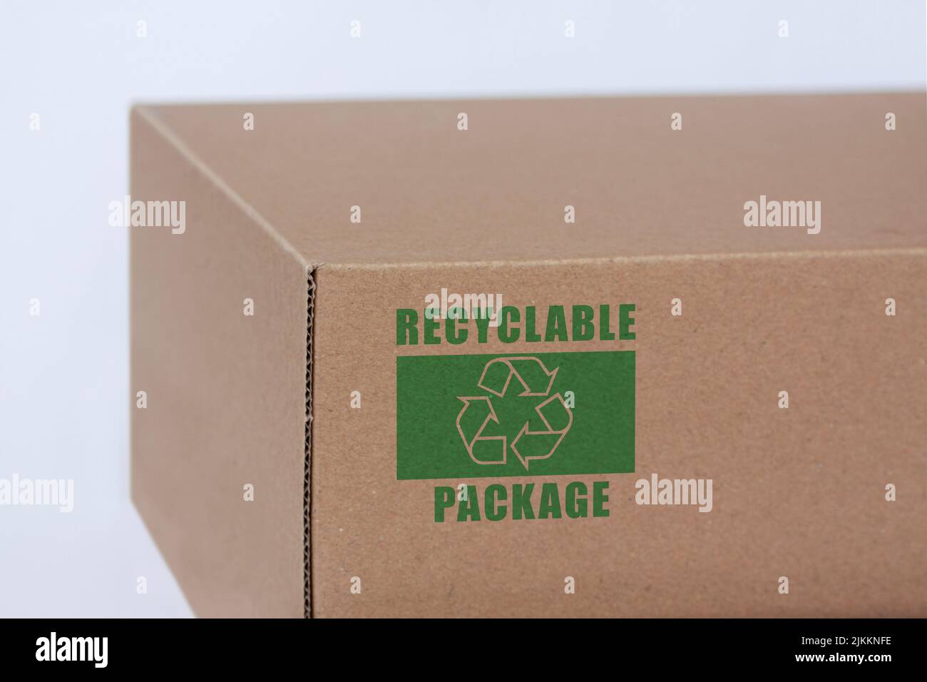Cardboard pakage with printed recycling symbol. Photo with while ...