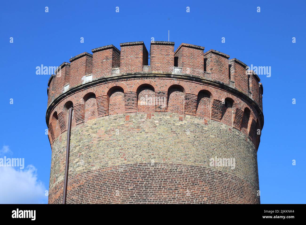 A low angle shot of the top of a big, brick tower against the blue sky ...